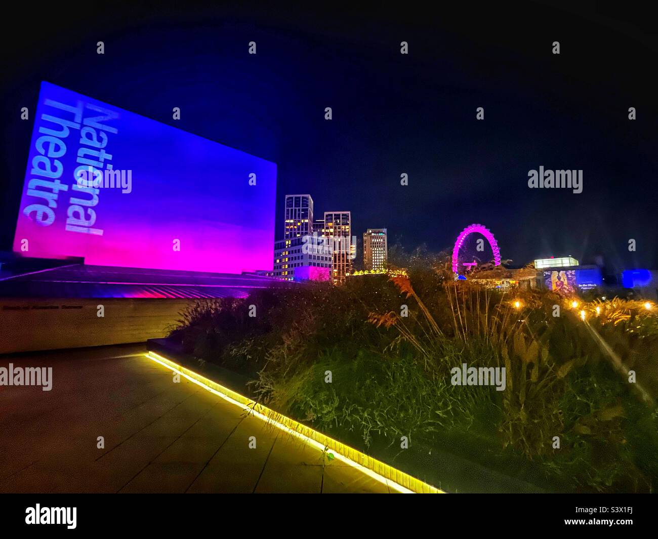 National Theatre Gallery illuminated at night with London Eye in ...
