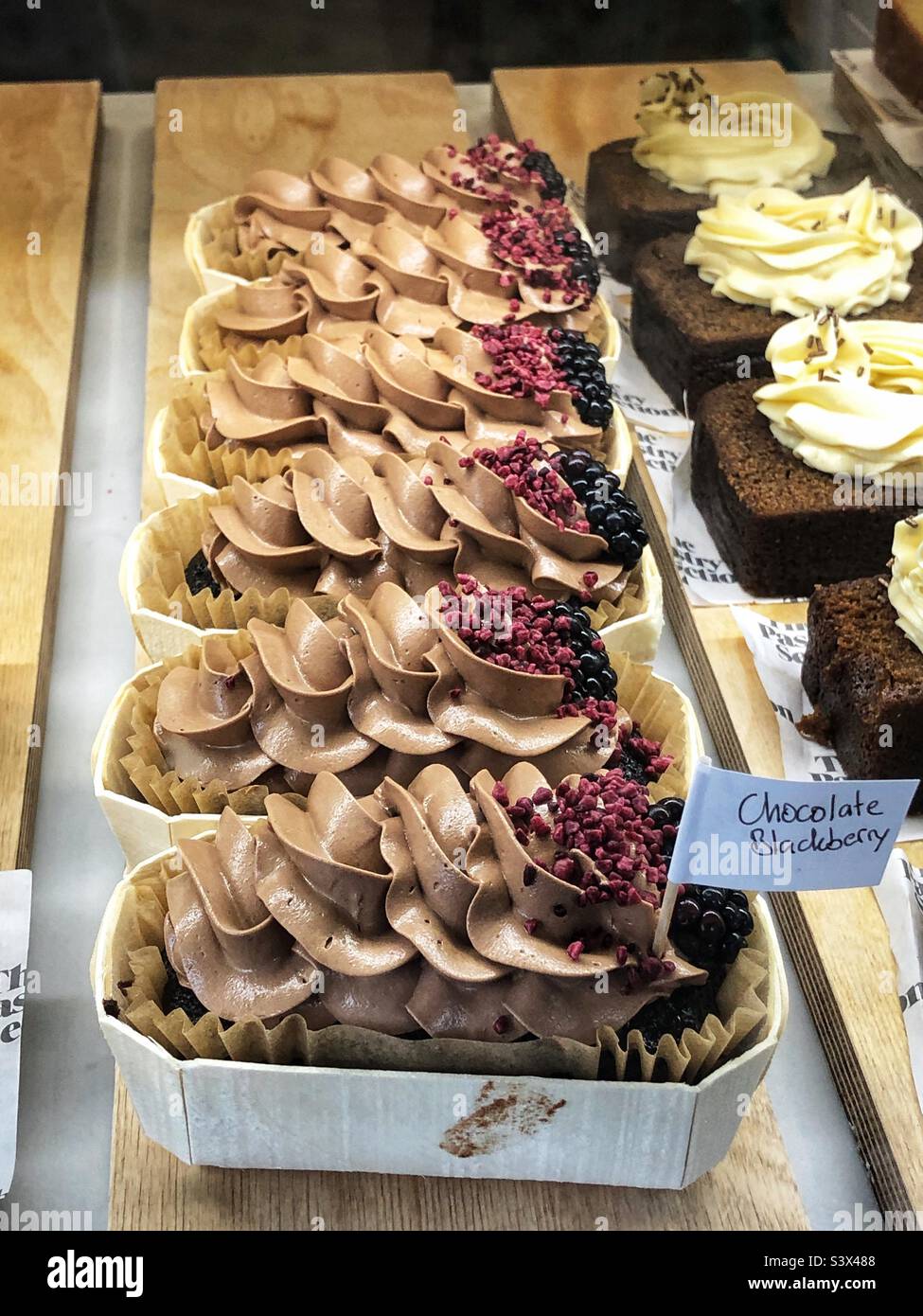 Cake Chocolate Blackberry in bakery window Stock Photo - Alamy