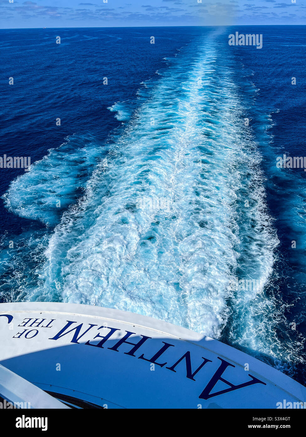 Cruise ship wake stretching from the stern to the blue sky horizon ...