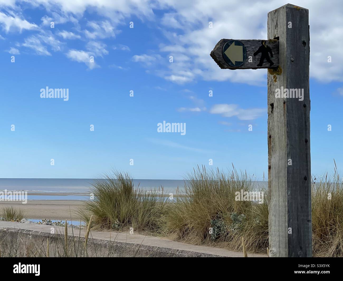 A sign at the beach showing the direction of the public footpath Stock ...