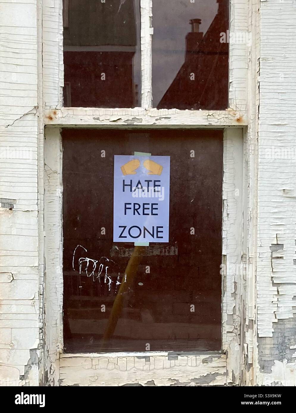 Hate Free Zone poster in a weathered old window Stock Photo - Alamy