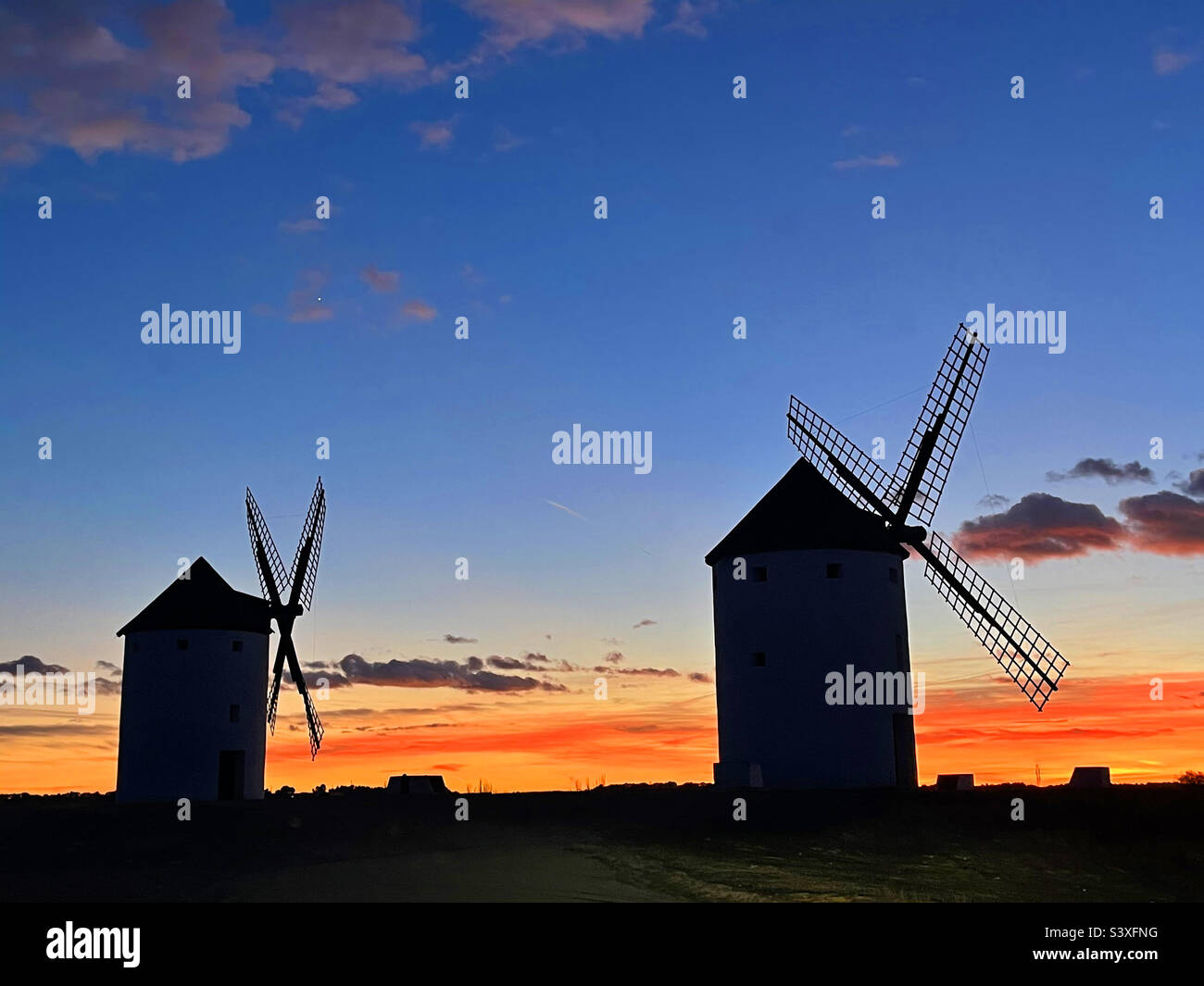 Two windmills at sunset Stock Photo - Alamy