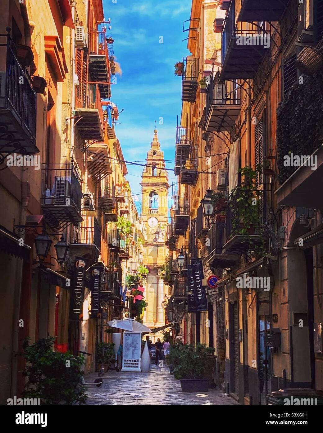 Street scene of narrow alley in Palermo Sicily with church tower at the ...