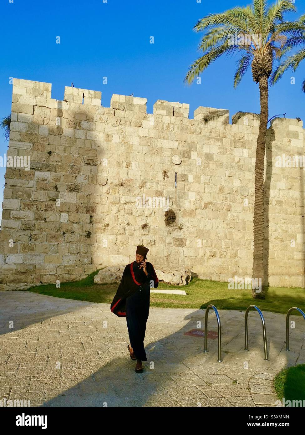 An Ethiopian priest walking by the walls of the old city of Jerusalem ...
