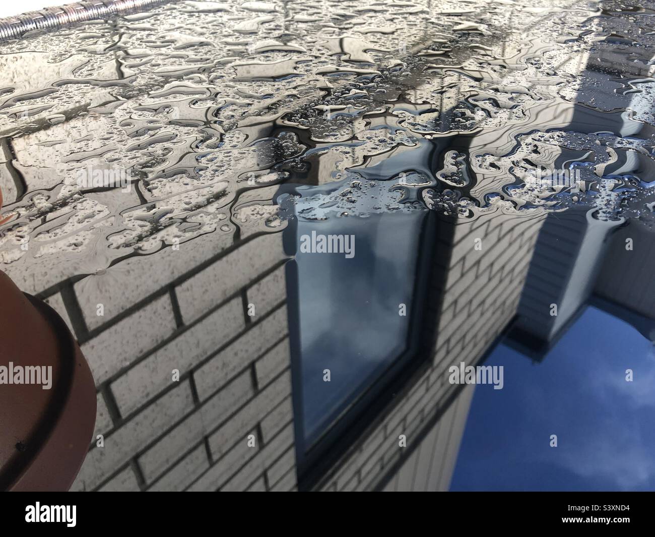 Glass table Puddle Reflection of brick house wall and window Stock ...