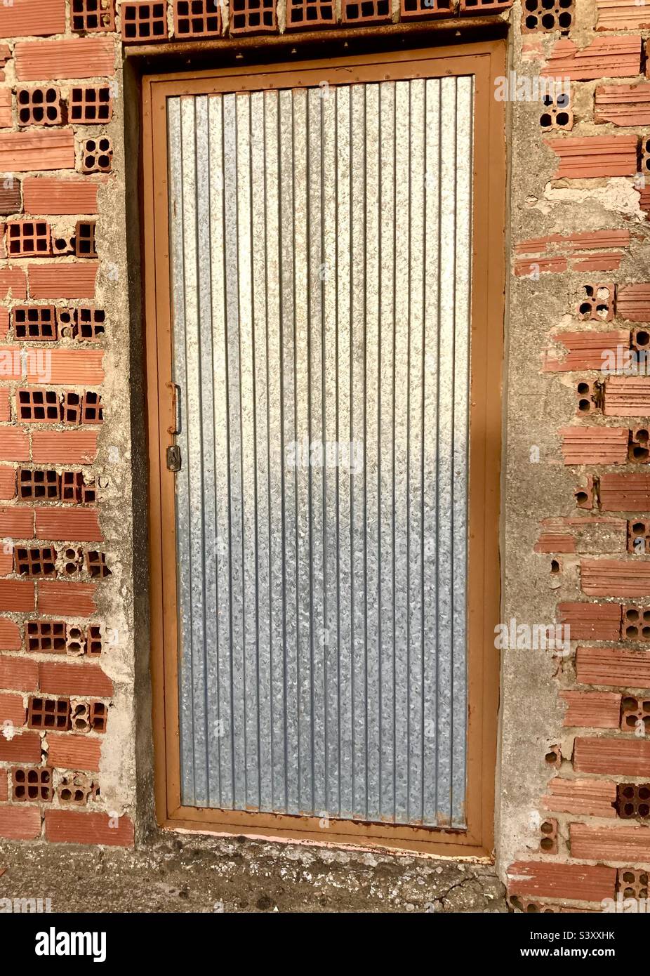 Basic unpainted metal corrugated door for a bodega in a village in ...