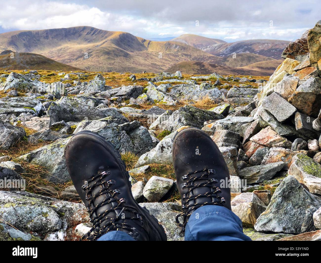 View of Walkers feet and leather boots at the summit of Carn a’ Gheoidh ...