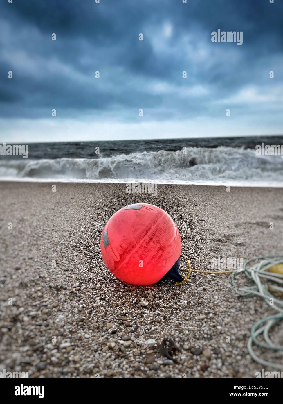 Buoy on the beach with waves breaking Stock Photo - Alamy