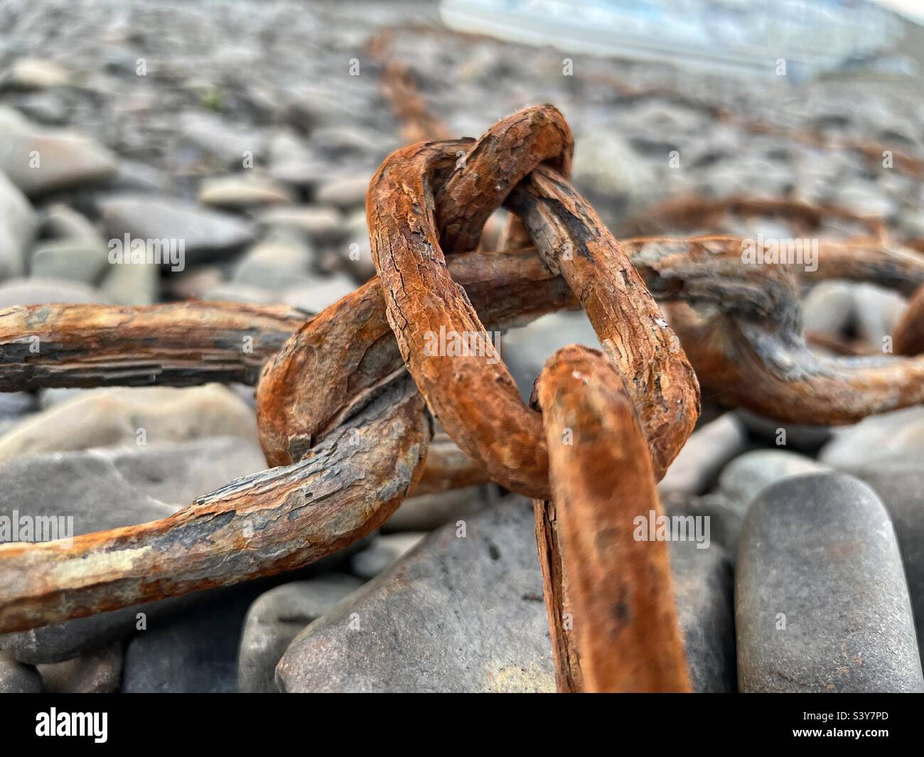 Close up of rusting metal chains on a stony beach Stock Photo - Alamy
