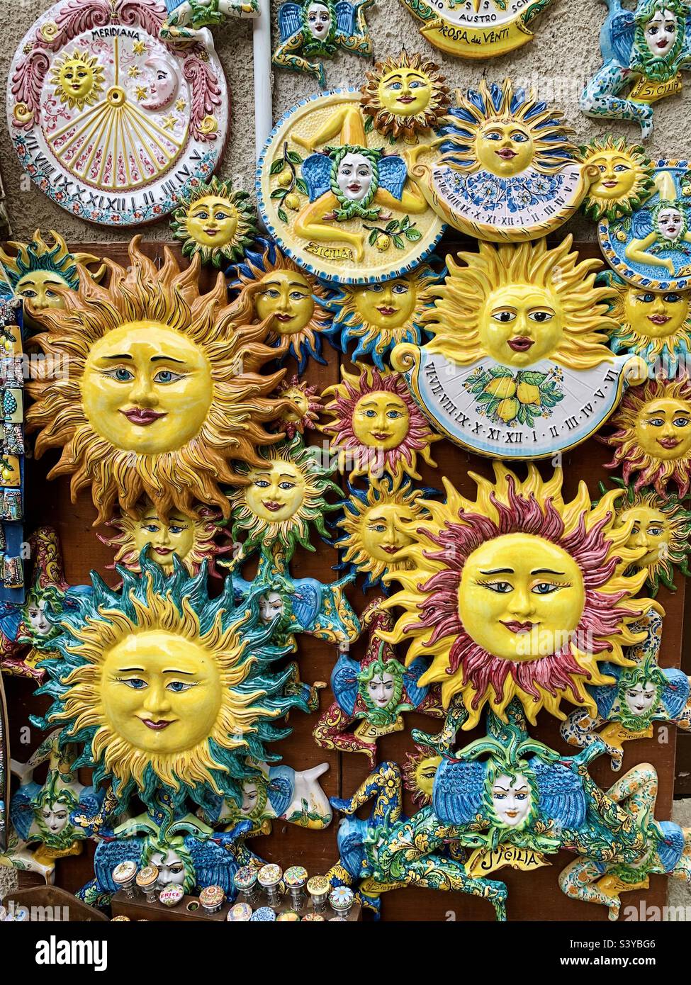 Colorful ceramic sun face souvenirs on sale in the medieval hill top ...