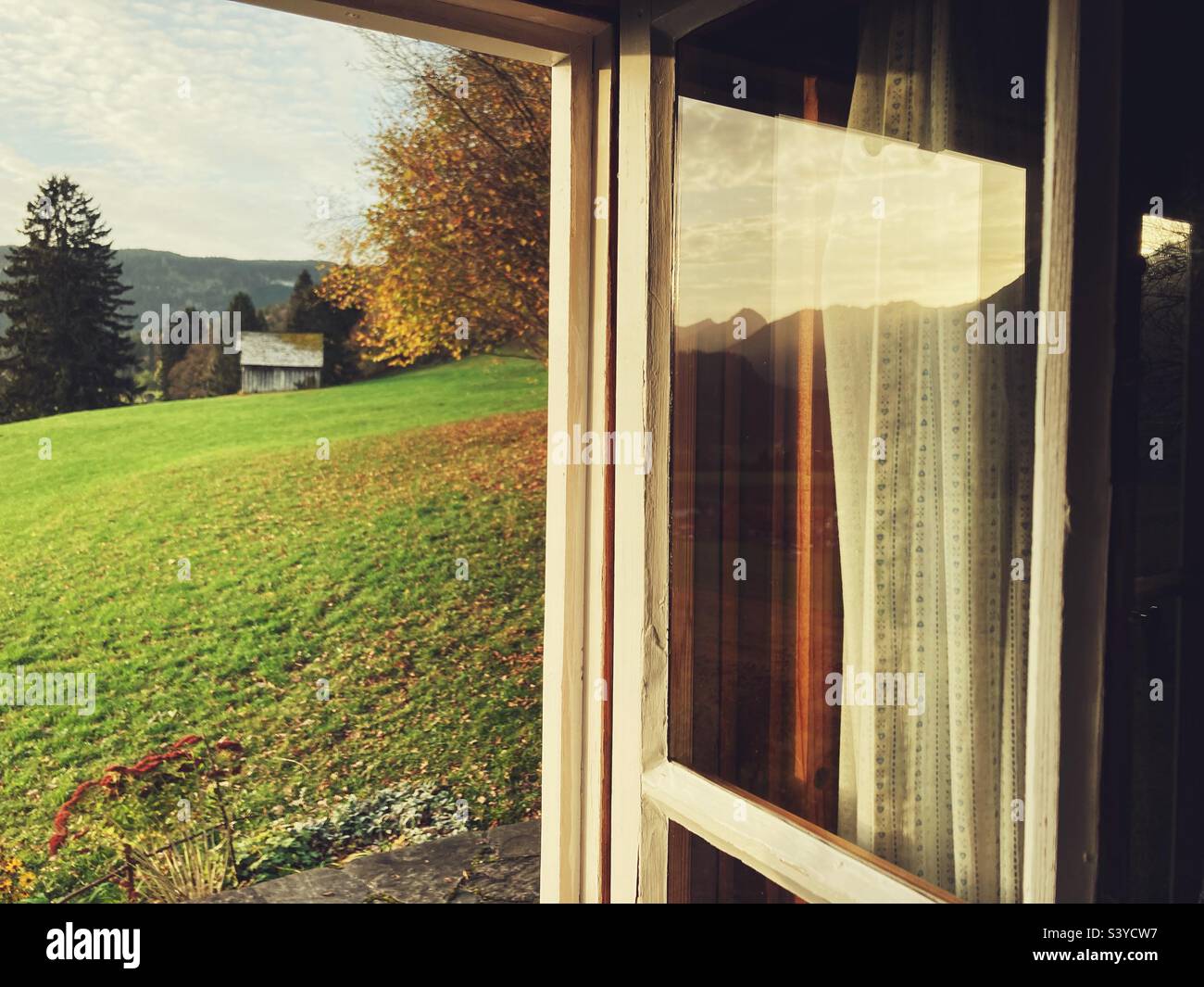 A view on a meadow in the German Alps from the window of a traditional ...