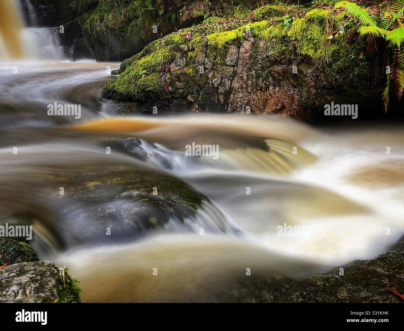 Soft, blurry water flowing over mossy rocks, Brecon Beacons, Wales ...