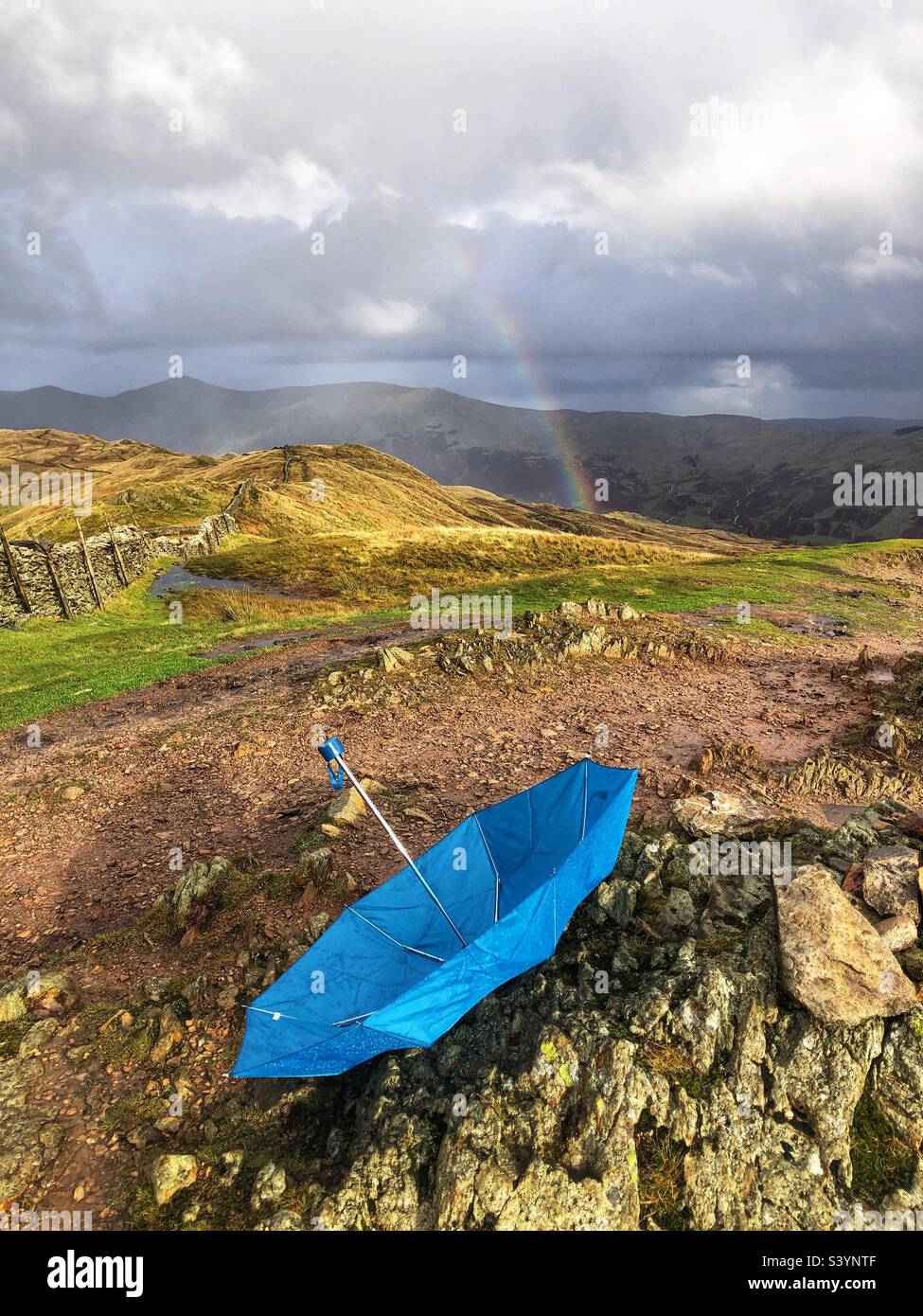 View from the summit of Wansfell Pike with a rainbow and wind blown ...