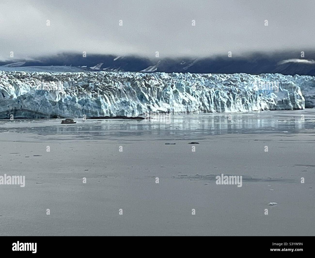 Double decked sightseeing boat for scale in front of the blue ice of ...