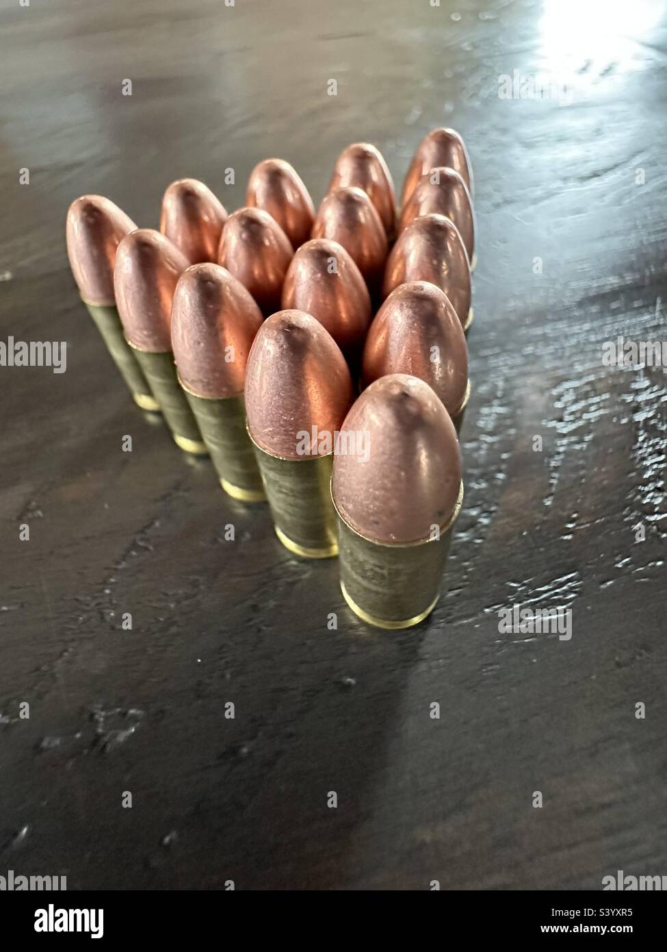 15 9mm bullets in the shape of a triangle Stock Photo - Alamy