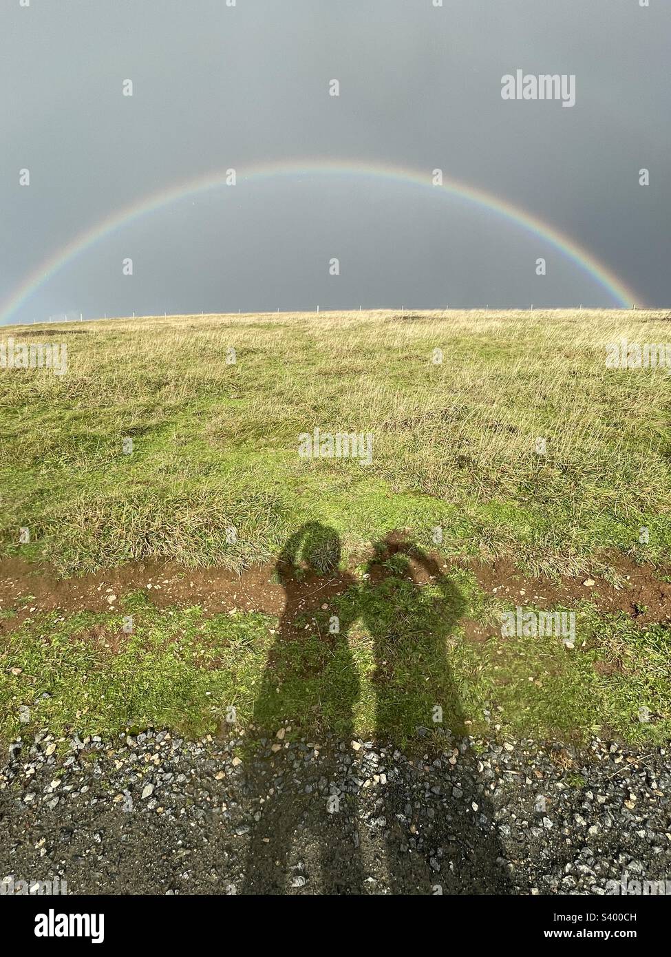 Two shadows of figures against a grassy hillside in Cornwall, England ...