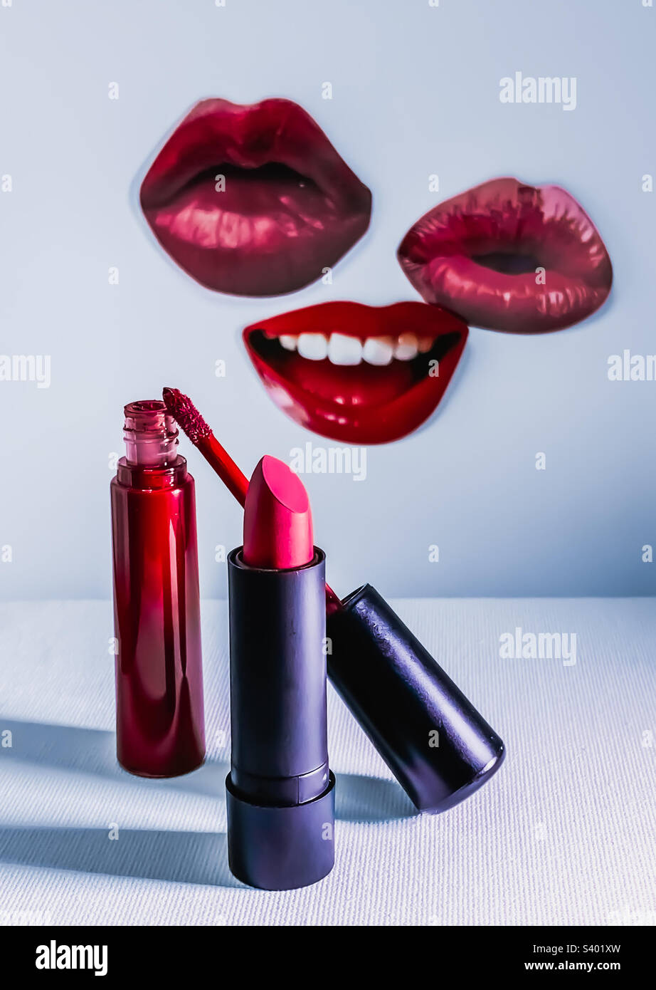 Red lipstick and lipgloss displayed in front of 3 pairs of cut out lips ...