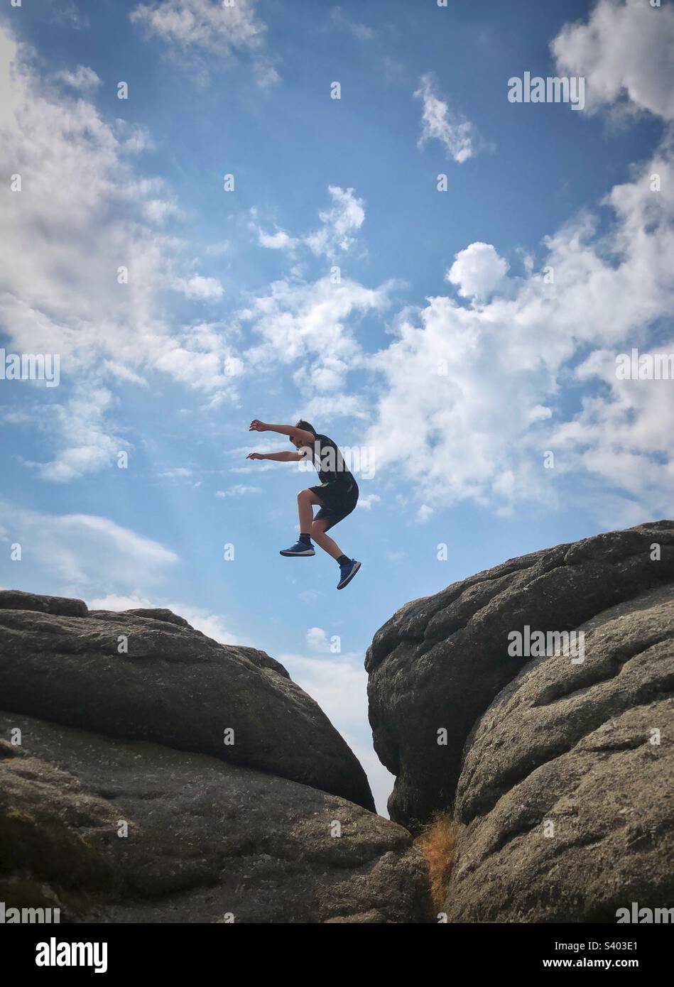 Jumping the gap at Haytor Rock Stock Photo - Alamy