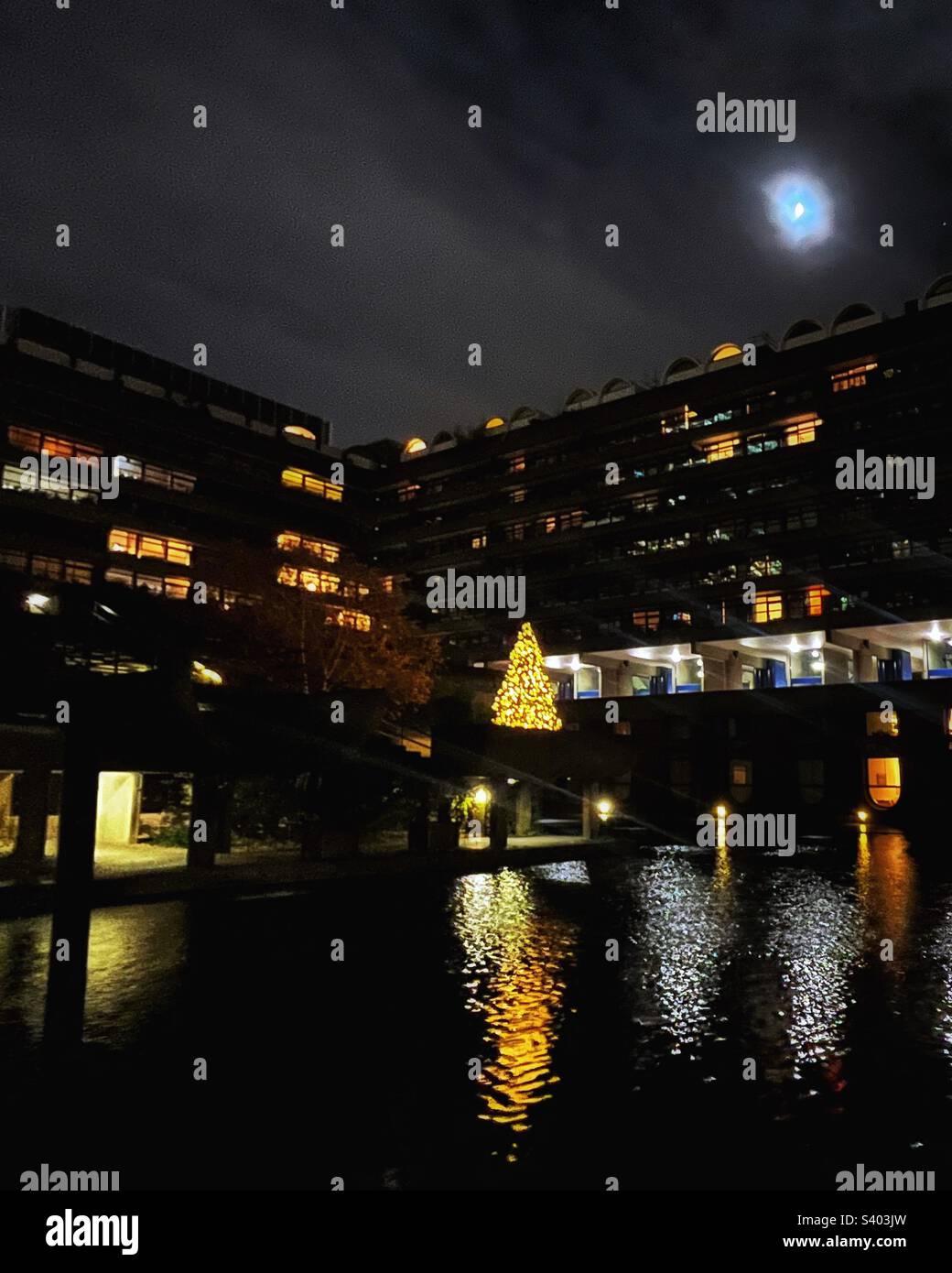 Christmas tree lights reflections in the Barbican lake in London at ...