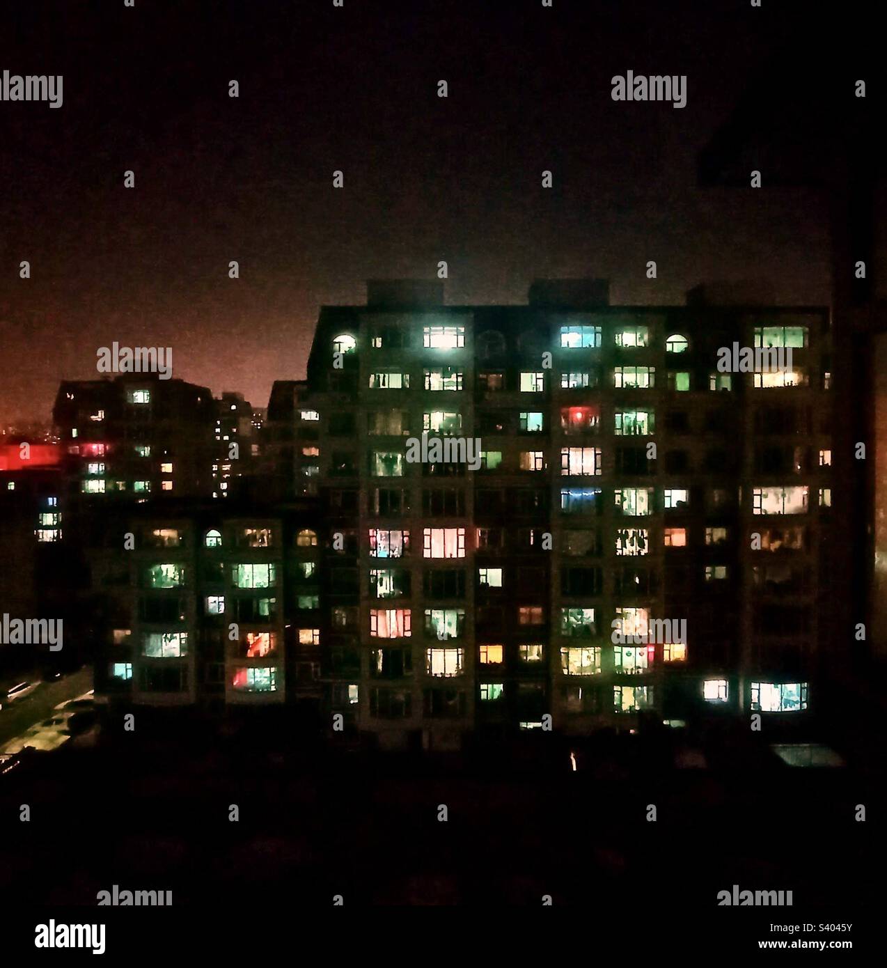 Romantic cityscape through my room’s window. In the night people turn ...