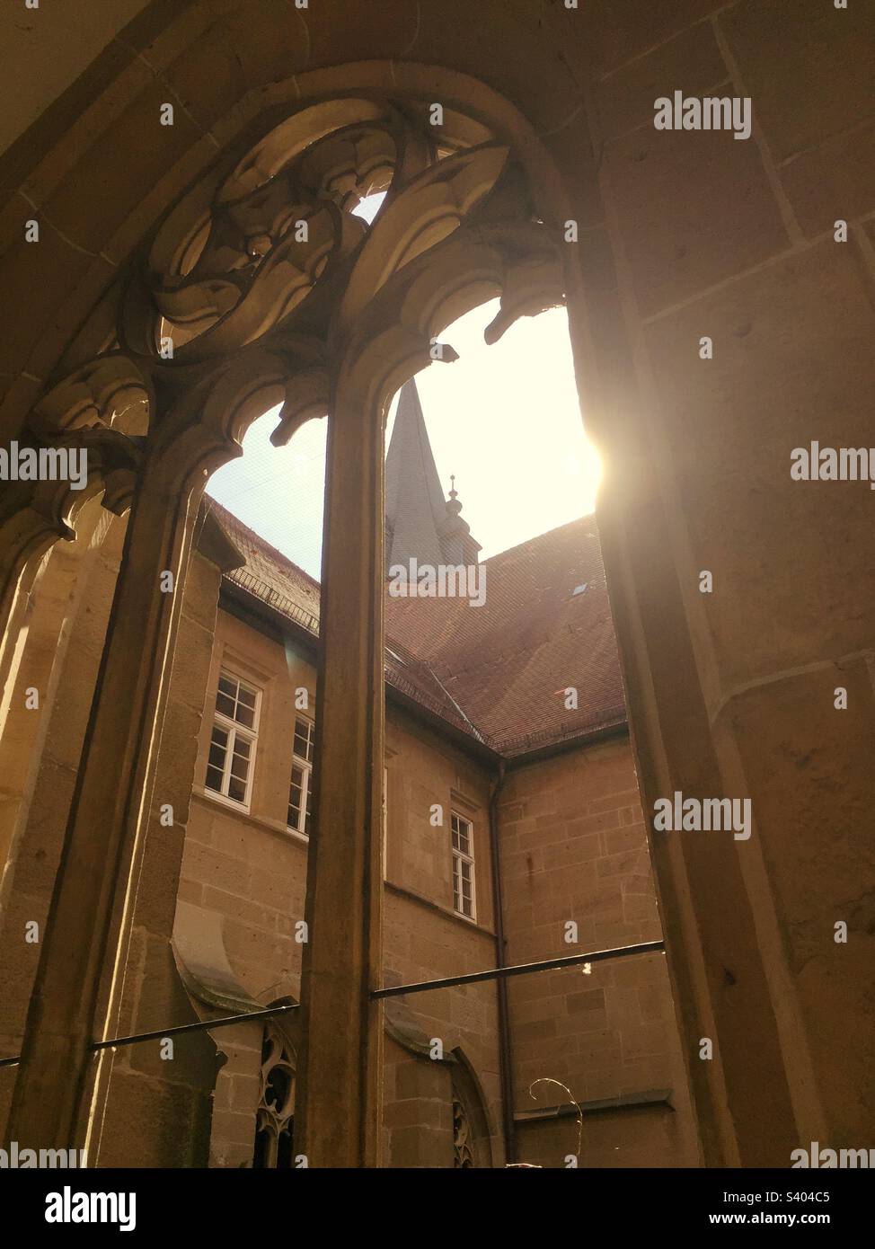 Tower of a medieval church through a decorated gothic stone window of a ...