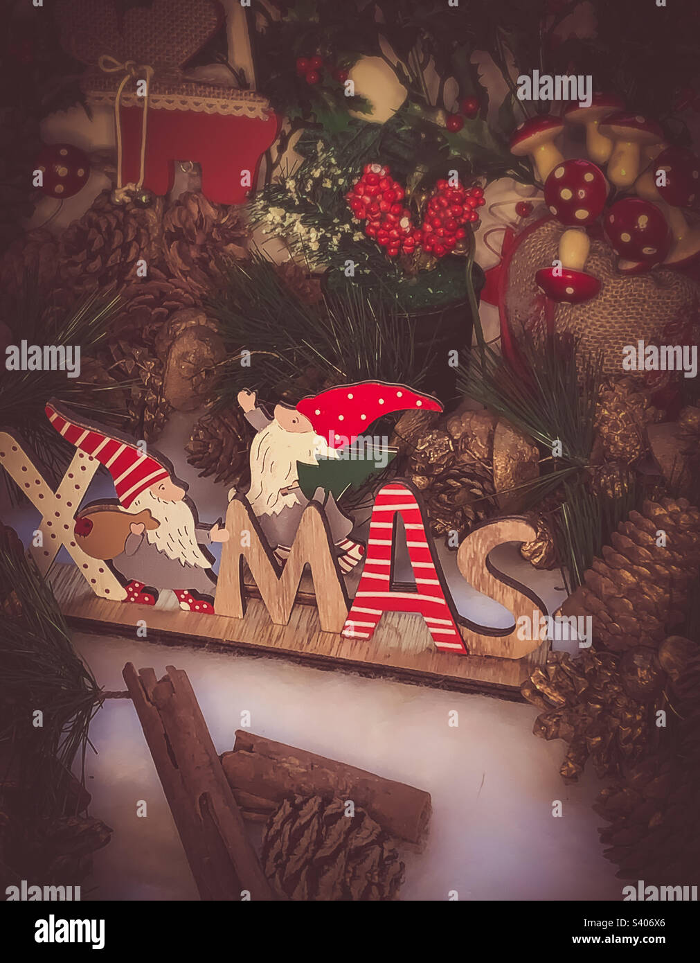 A wooden sign states Xmas and is surrounded by Christmas paraphernalia ...