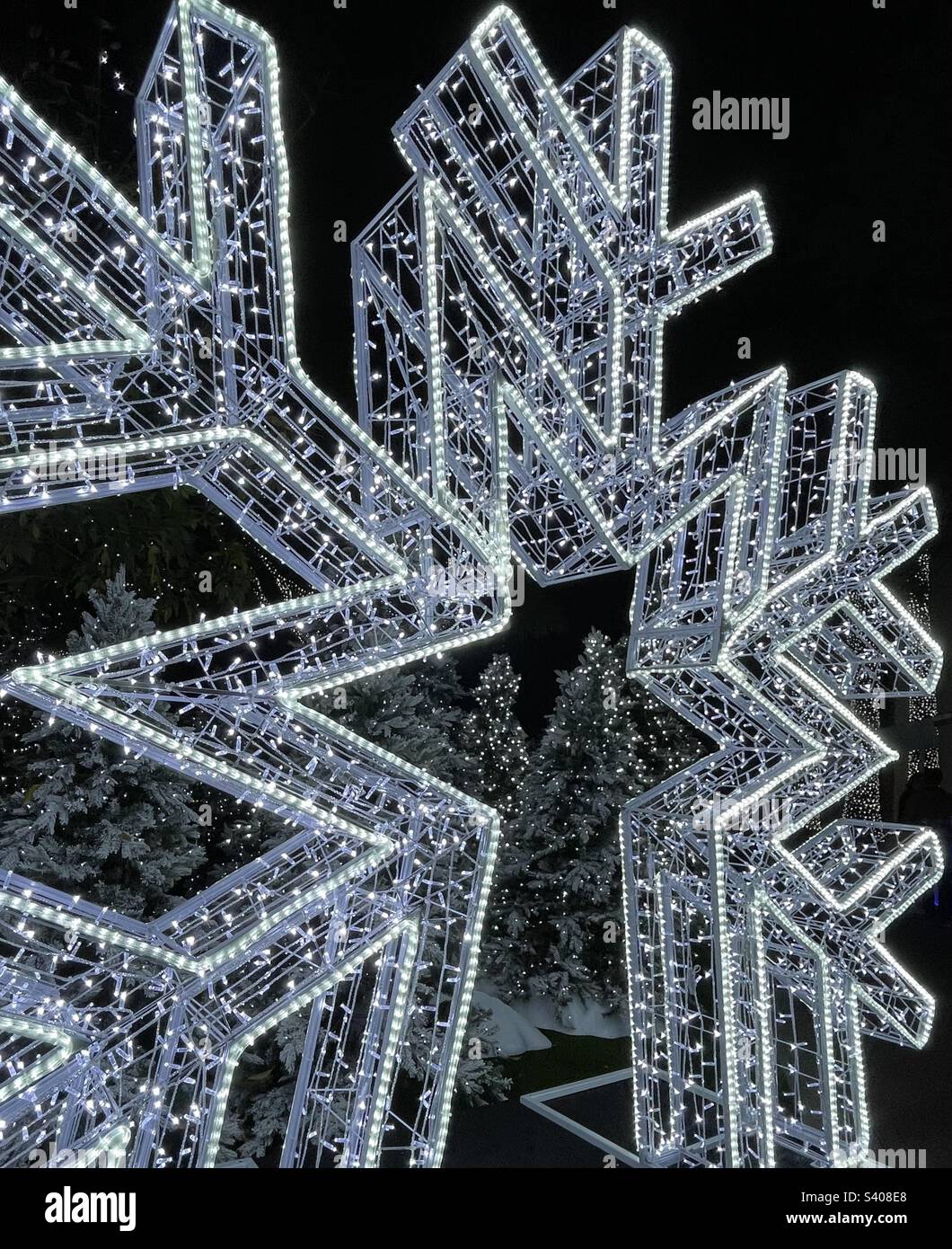 Angled view of large sparkling white snowflake display framing ...