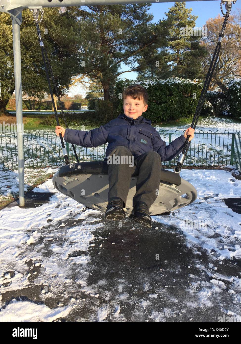 Swing in the snow Stock Photo - Alamy