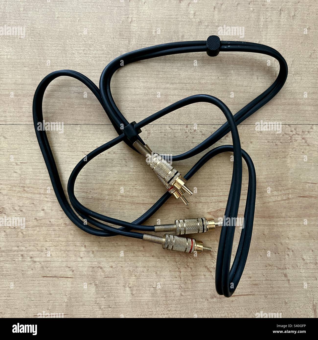 Black, stereo audio cable with gold-plated phono connectors on both ...