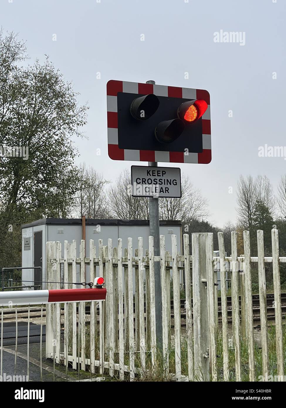 Red light signal at train crossing with barriers down Stock Photo - Alamy