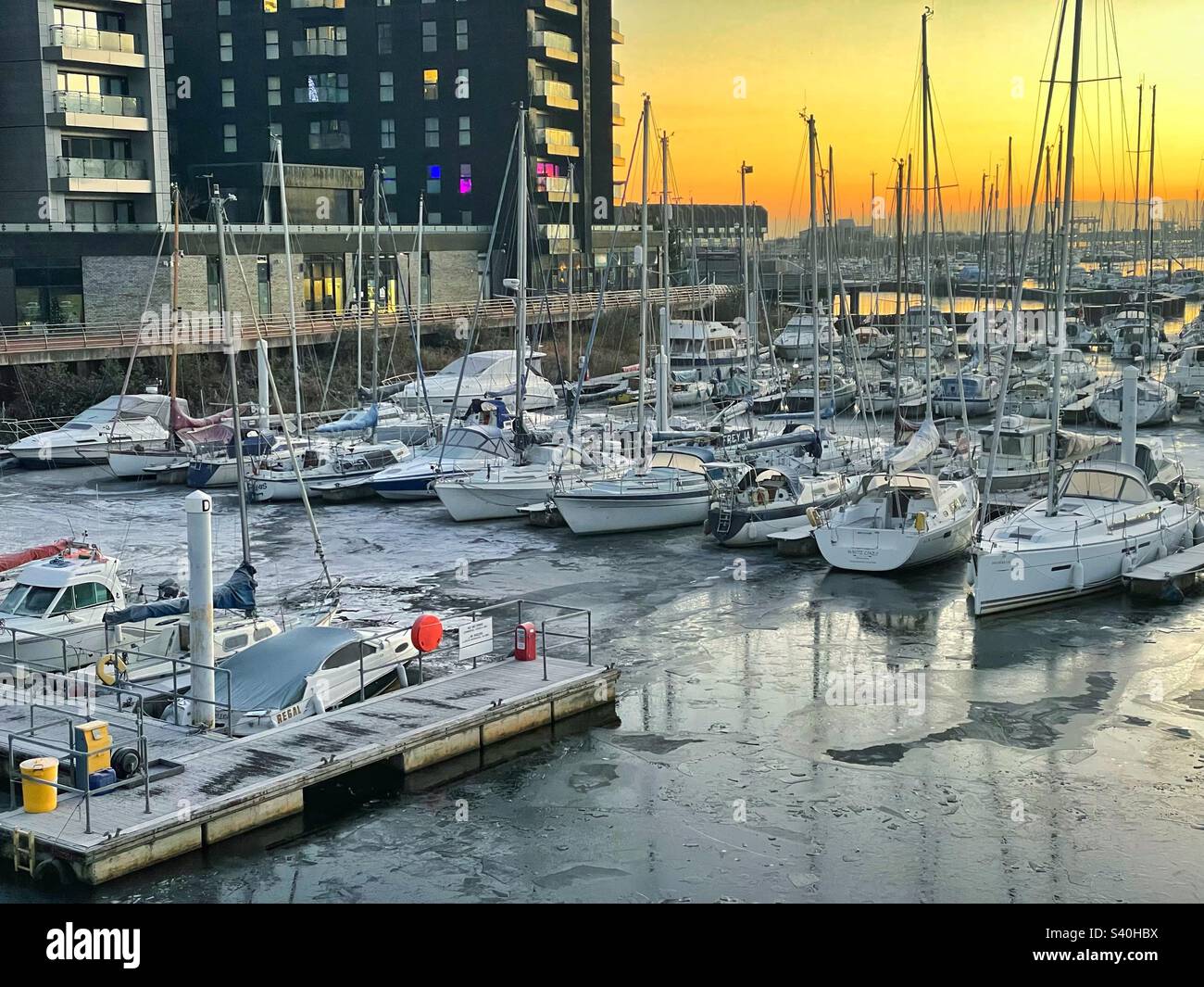 Boats moored at Penarth marina with icy water around them. Frozen river ...