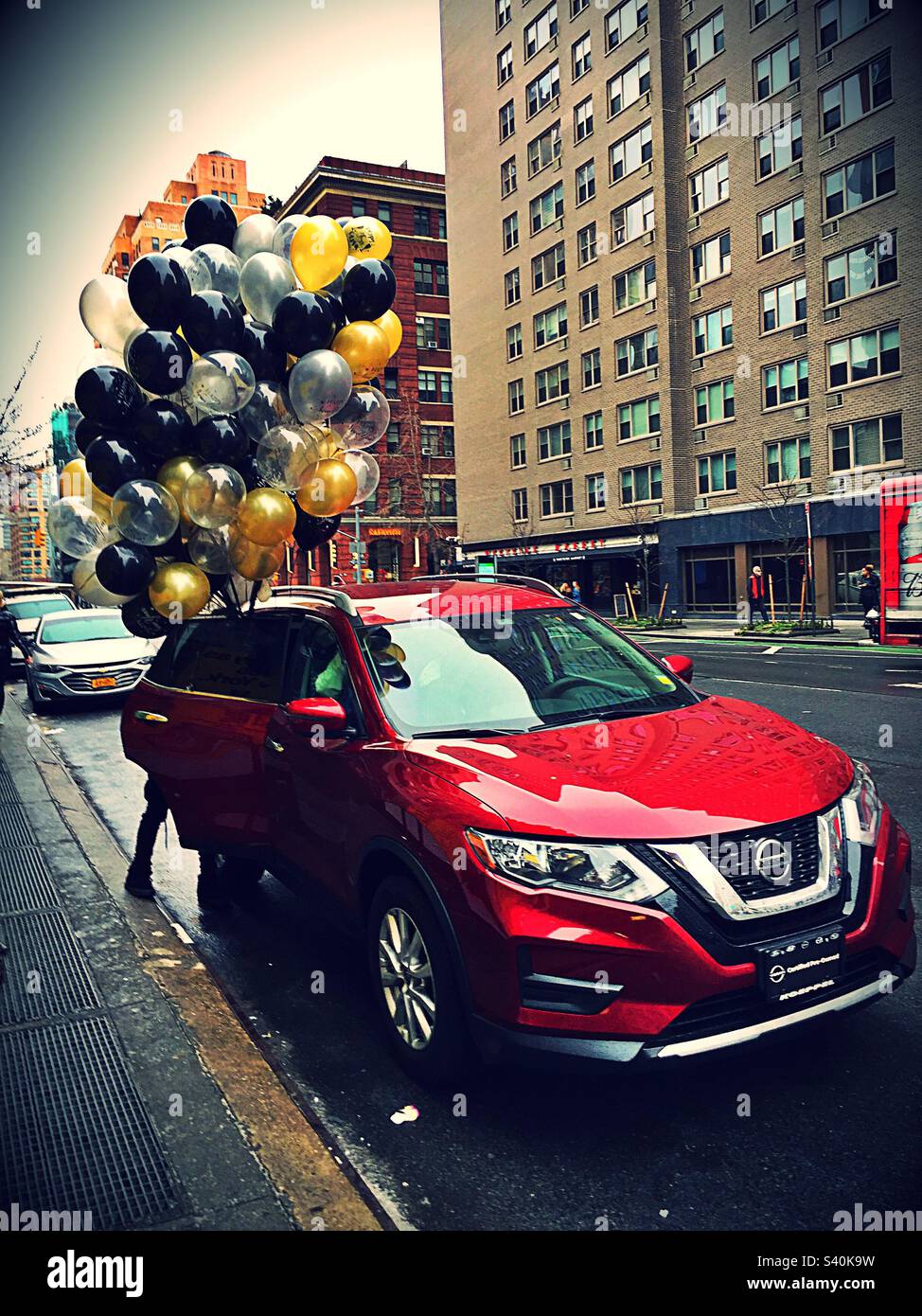 Enormous bunch of balloons taken from red car Stock Photo - Alamy