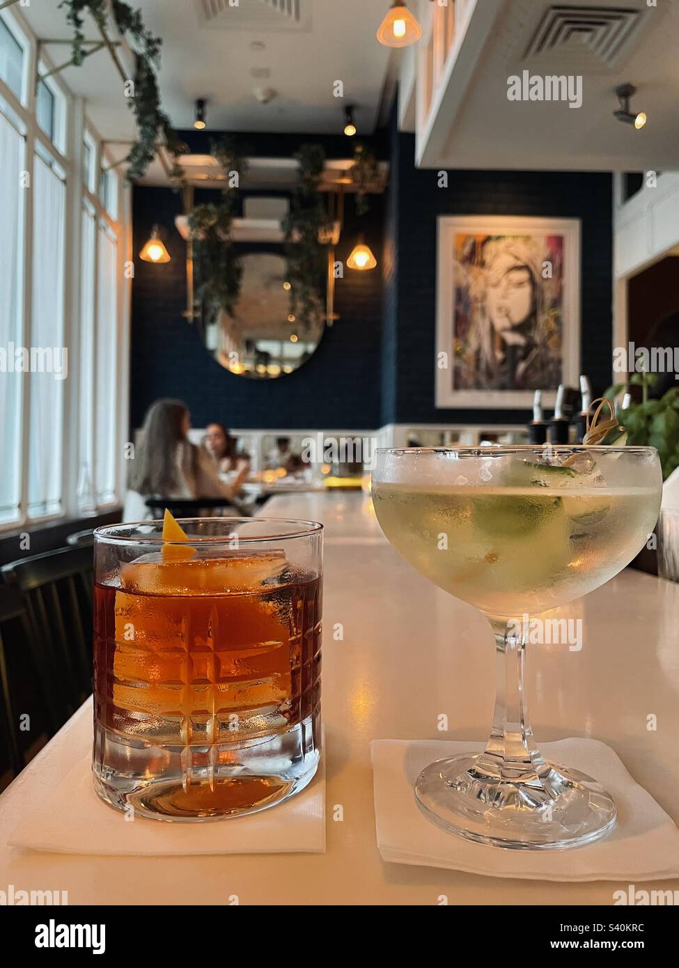 Drinking coctail in a bar. One of the coctails are orange and the other ...