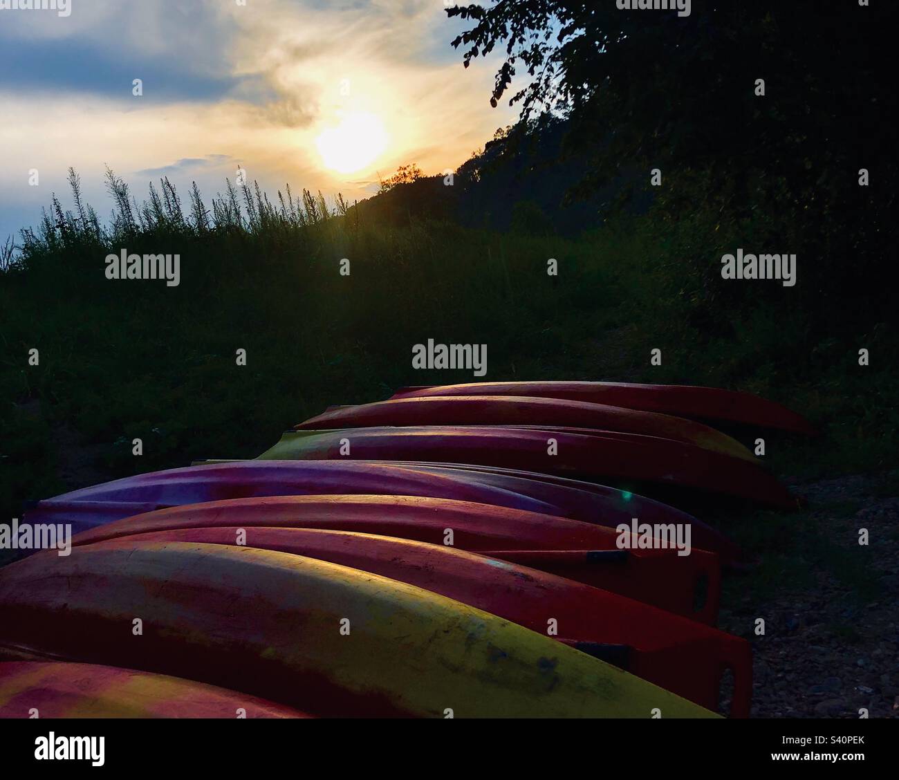 Canoes at sunset Stock Photo - Alamy