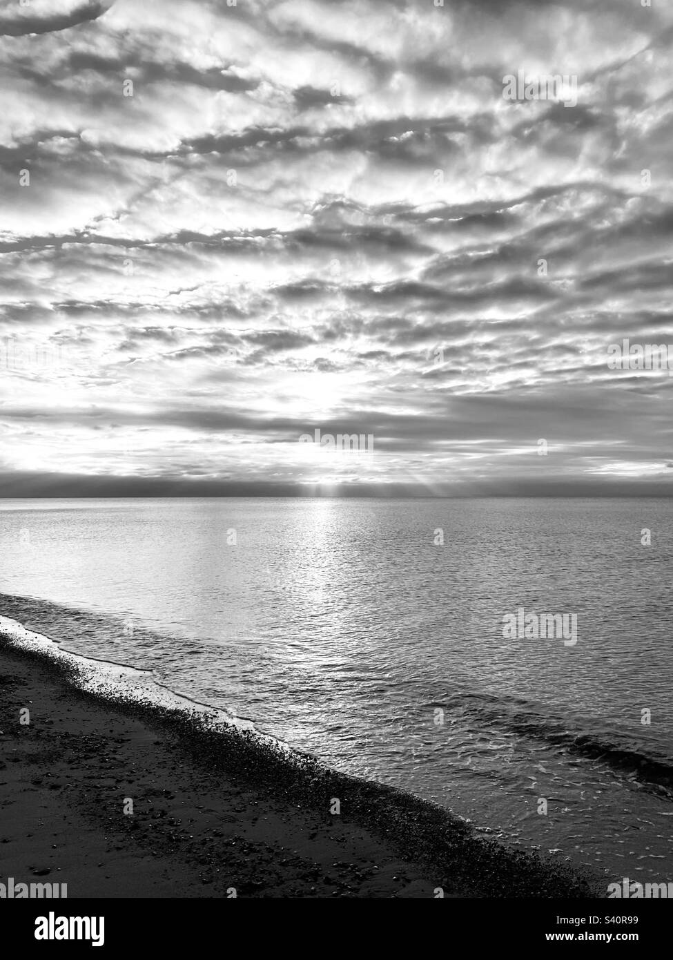 Sun rays shining through layers of clouds. Atlantic Ocean and the beach ...