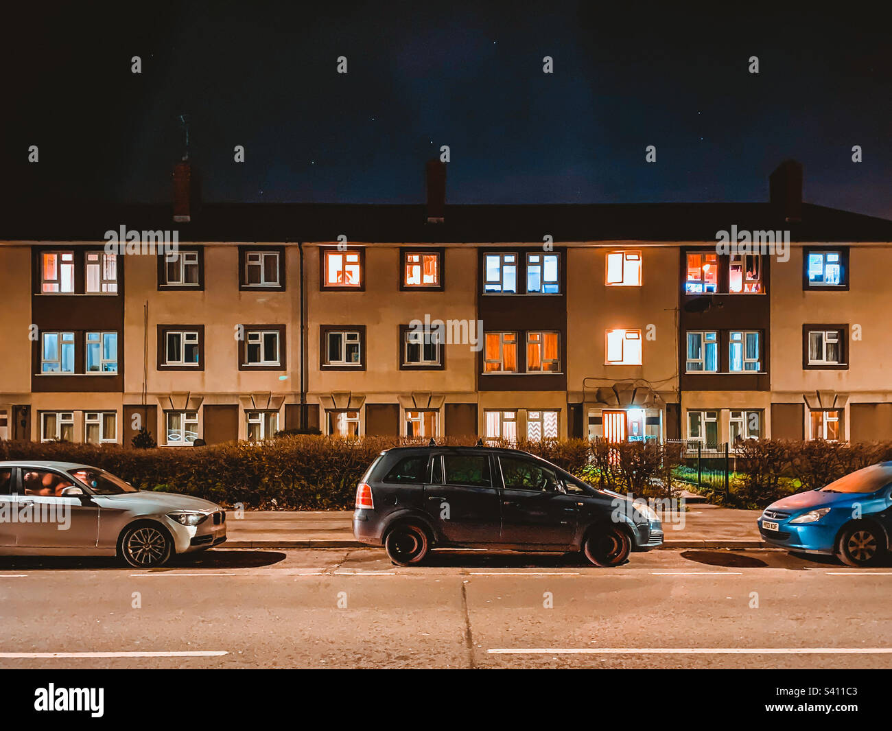Cars parked outside a block of flats at night Stock Photo - Alamy