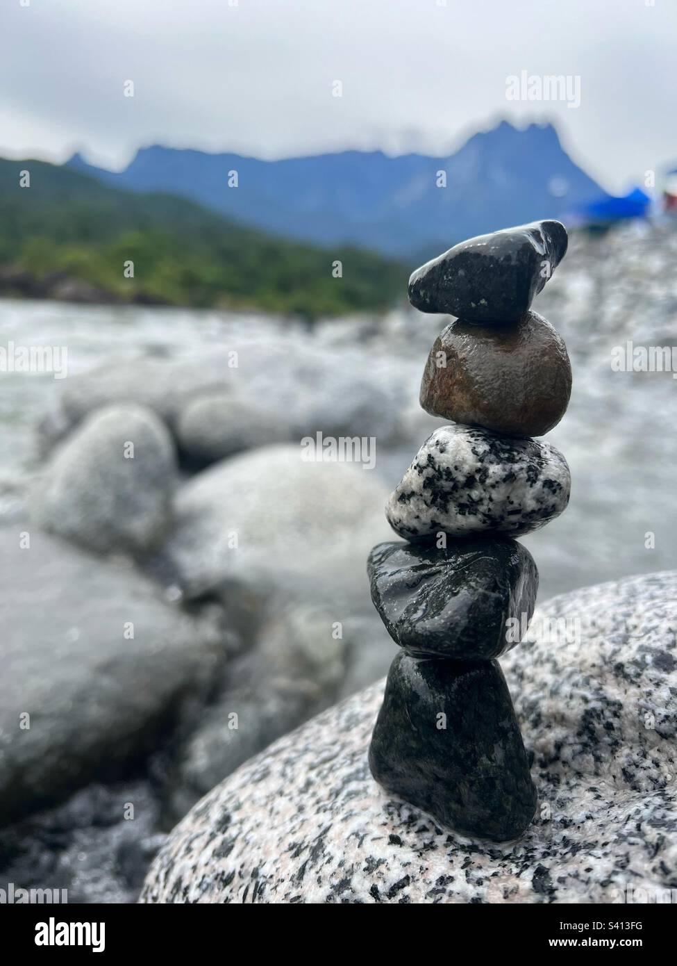 Stacked river stones with Mount Kinabalu as background Stock Photo - Alamy