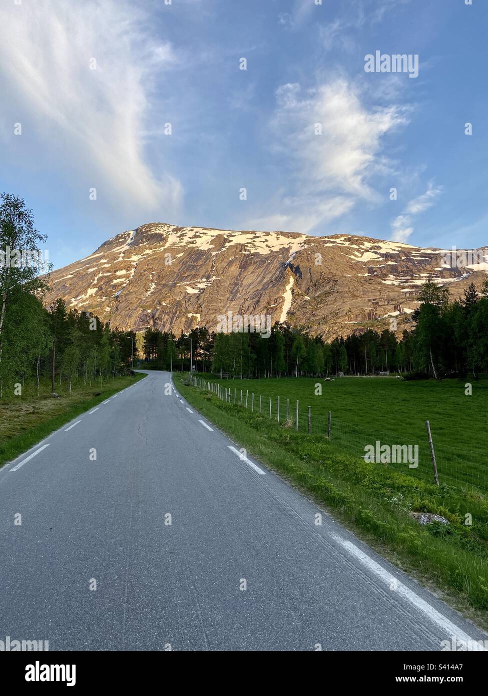 Road in Nordland, Norway on a sunny summer night. Midnight sun is ...