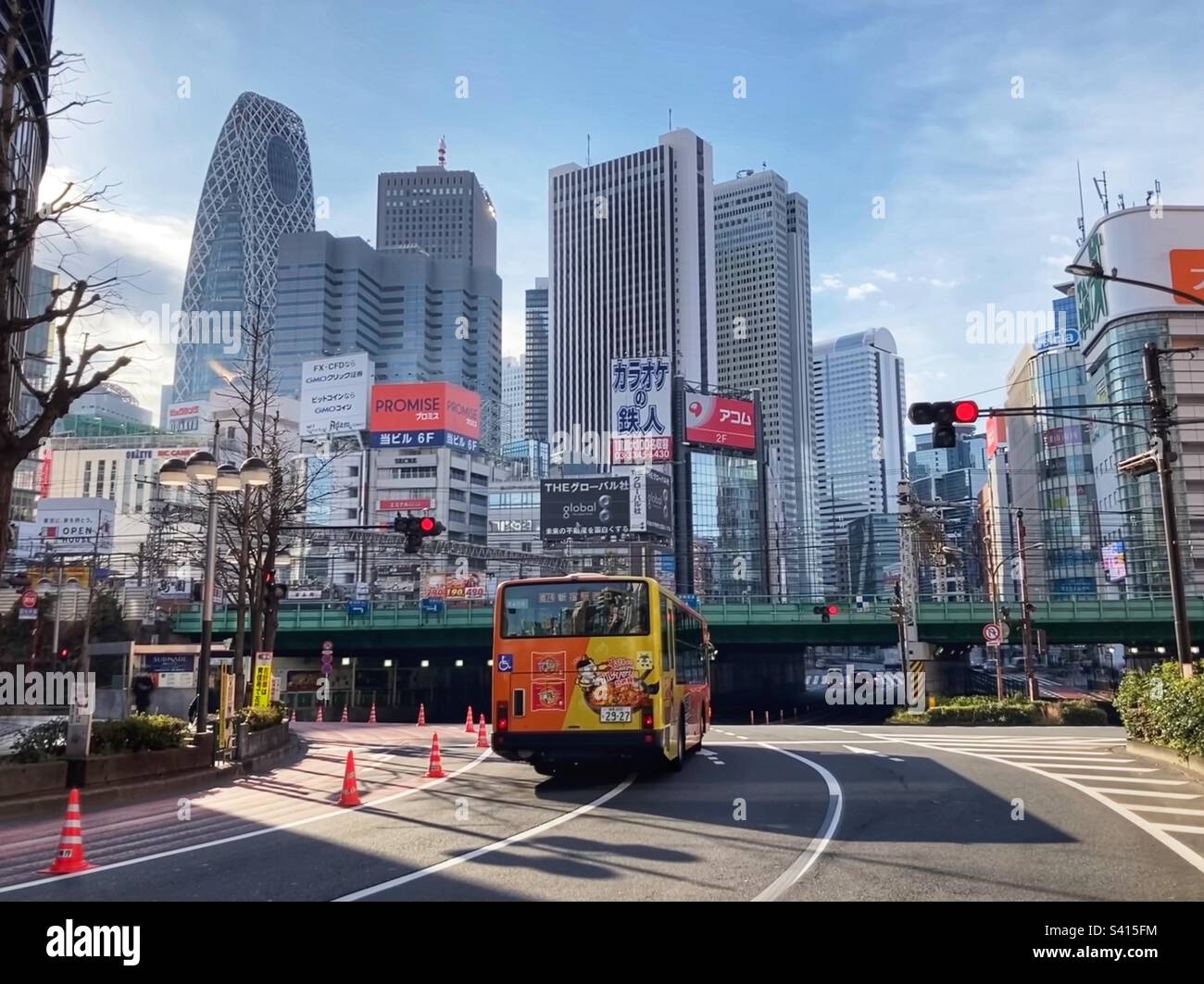View on the skyscrapers of Shinjuku with an orange bus in foreground ...