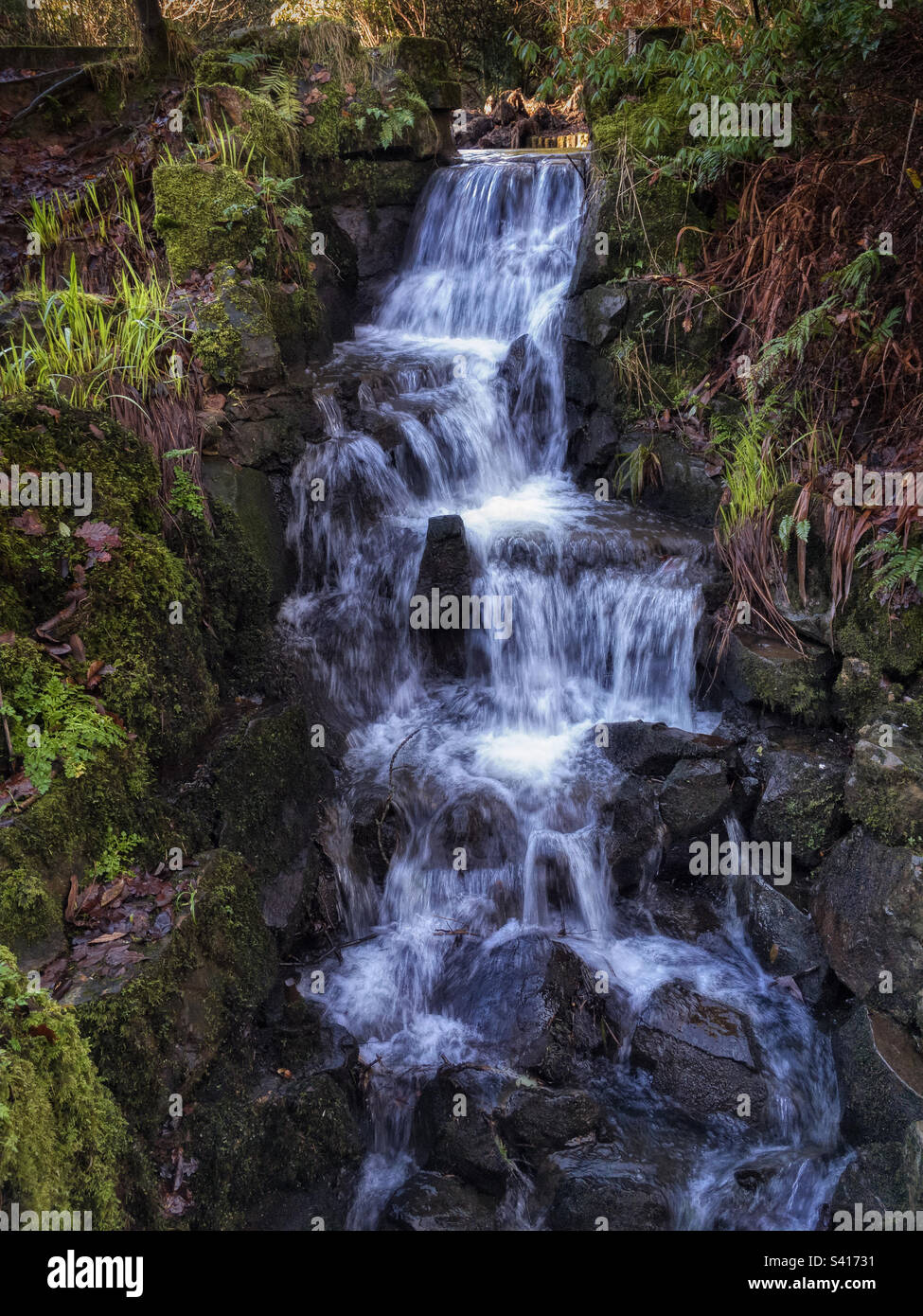 Small waterfall on green rocky slope Stock Photo - Alamy