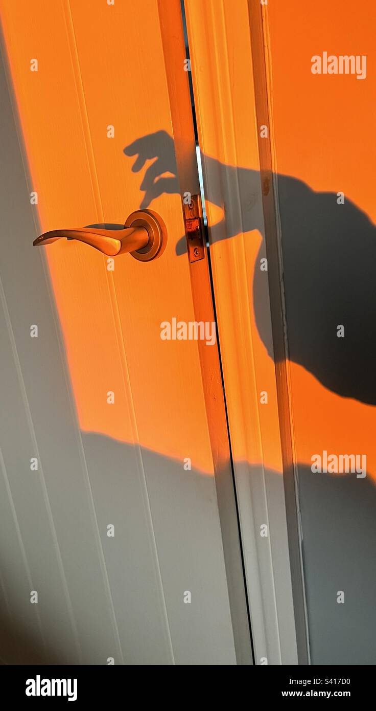Shadowy hand reaching for a door handle Stock Photo - Alamy