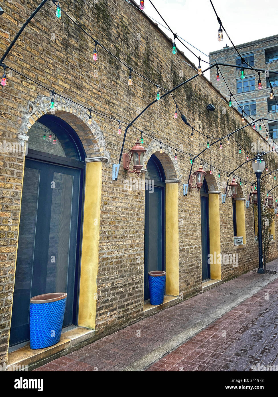 Brick alley with decorative lights Stock Photo - Alamy