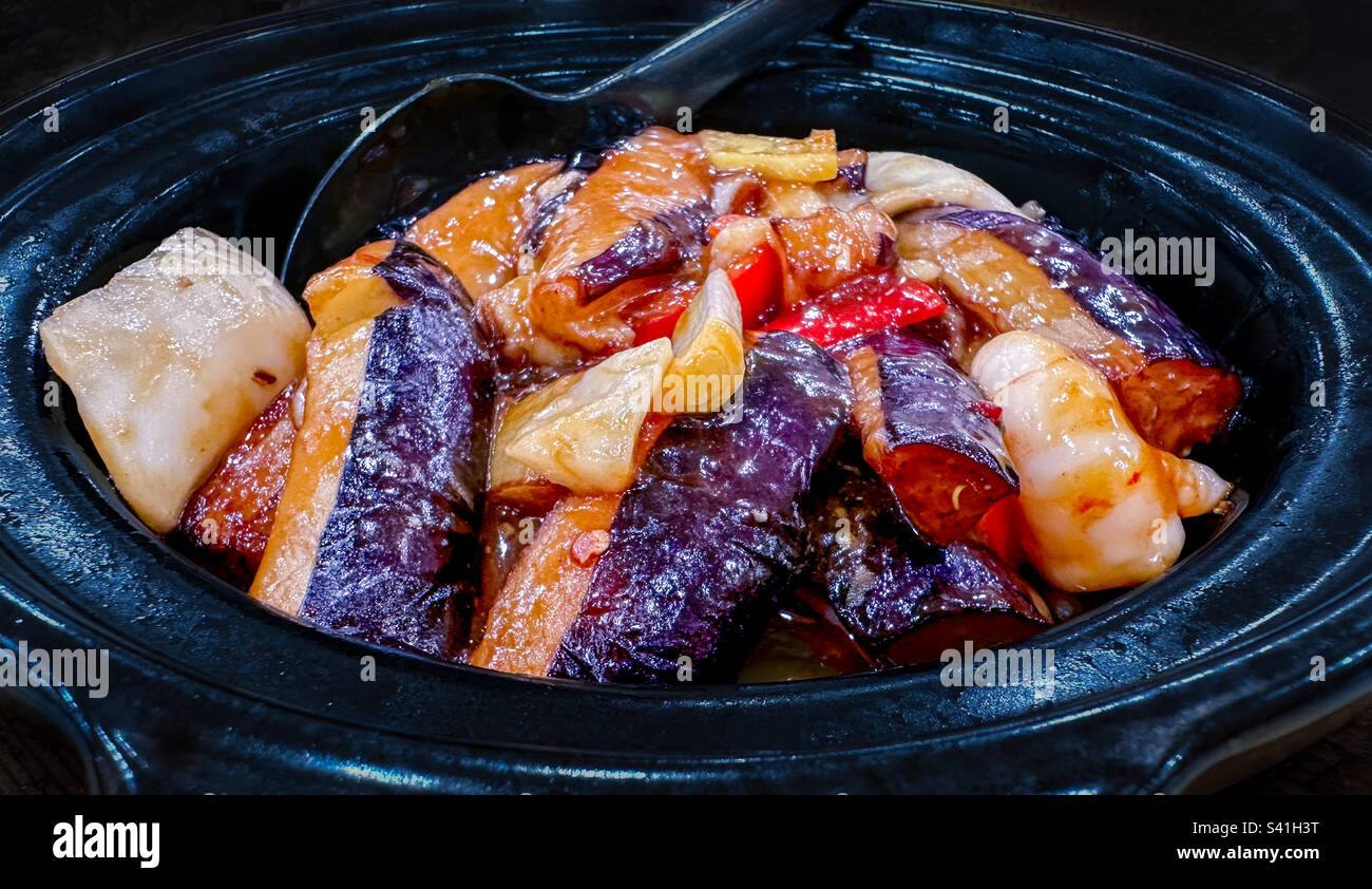 Eggplant and cod hot pot, a Chinese dish prepared in a heated ceramic ...