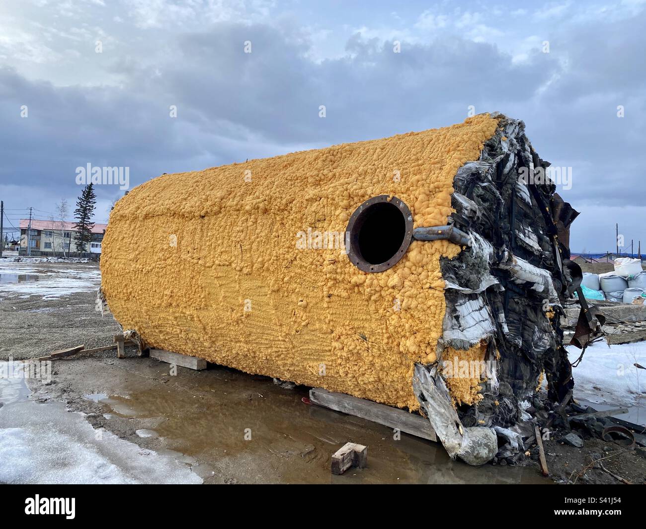 A large tank barrel filled with insulated mounting foam stands in the ...