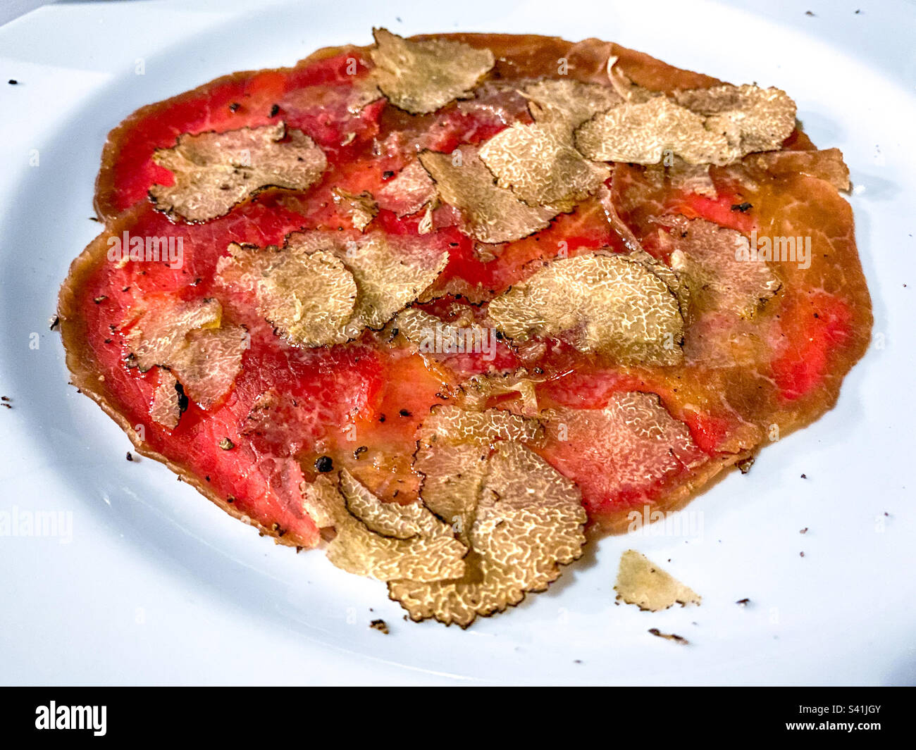 Plate of beef carpaccio with truffle garnish at Italian restaurant ...
