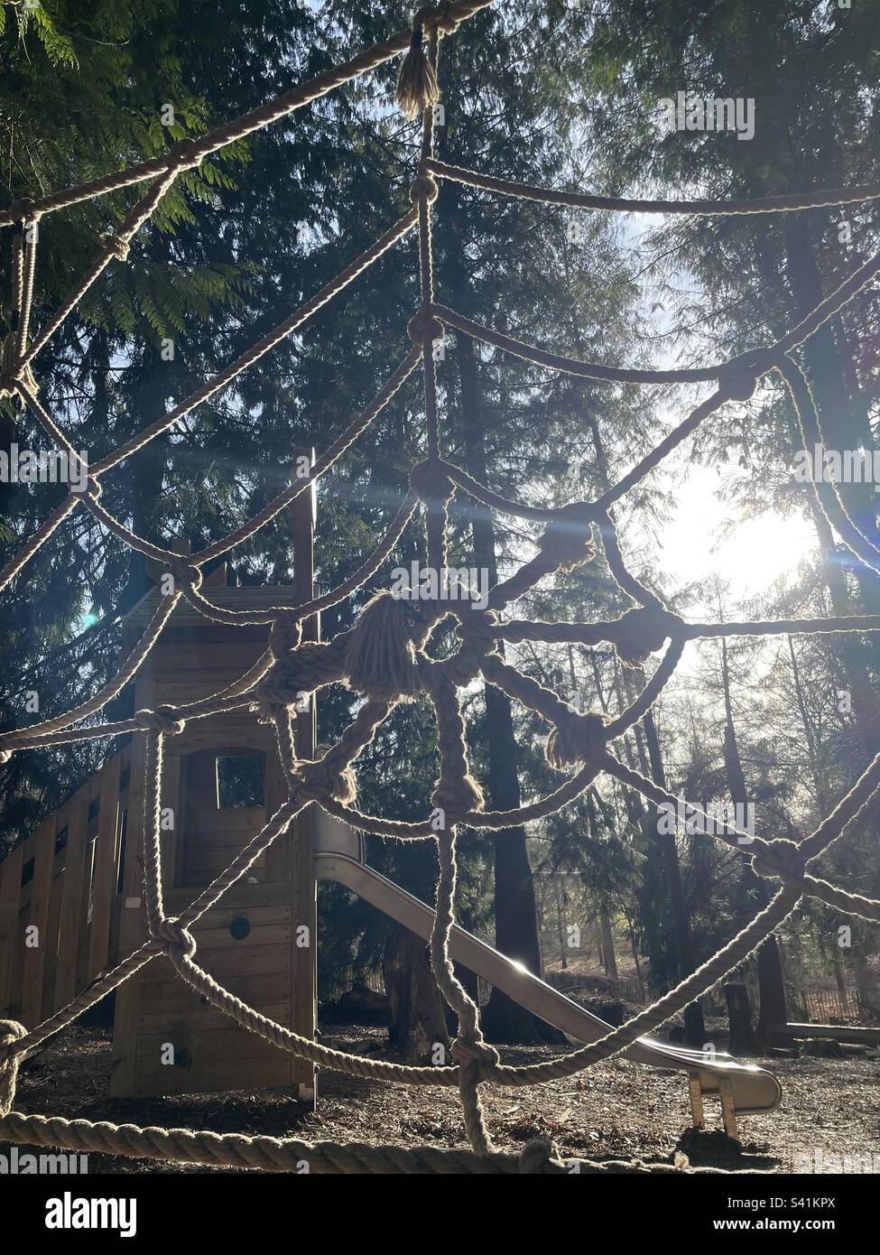 Children’s playground through the eyes of a rope spider’s web near ...
