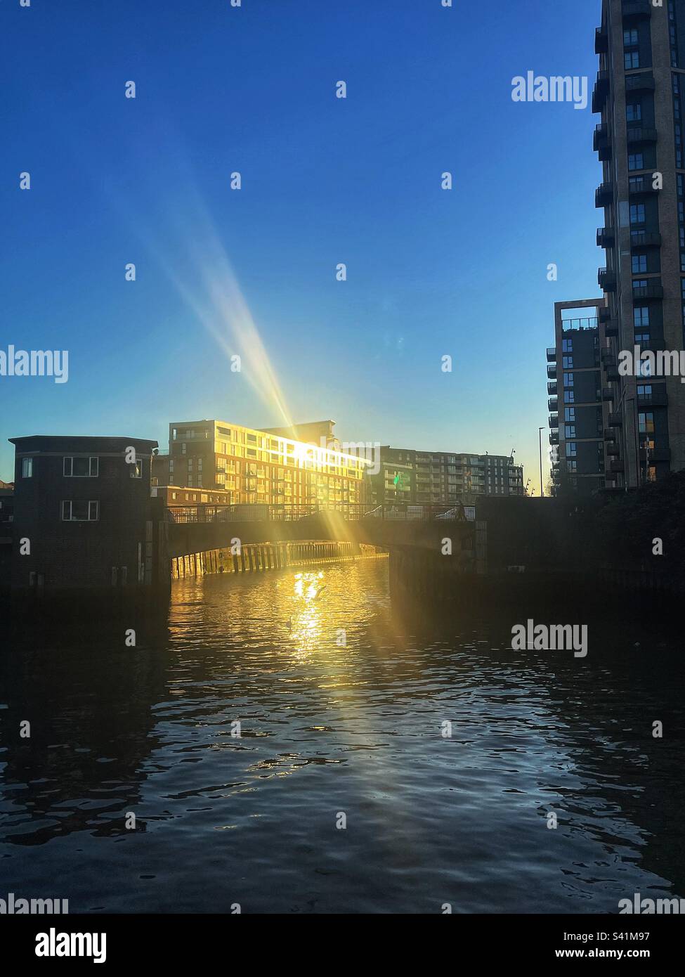 Sun hits the buildings on the banks of Deptford Creek as it flows into ...