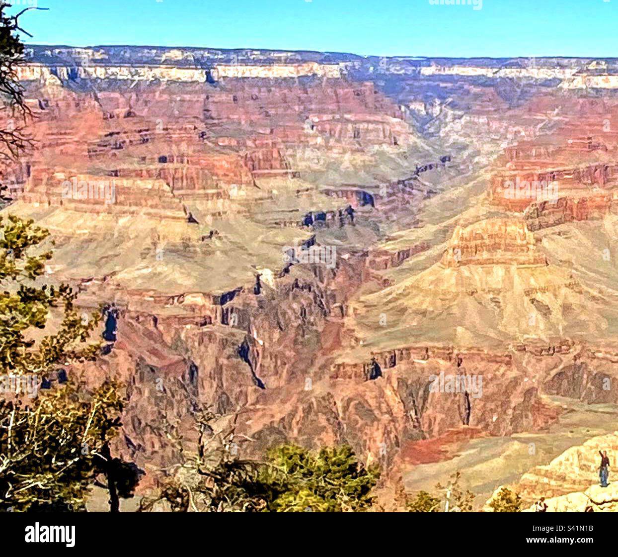 Man standing at edge of cliff on lower right hand corner of picture ...