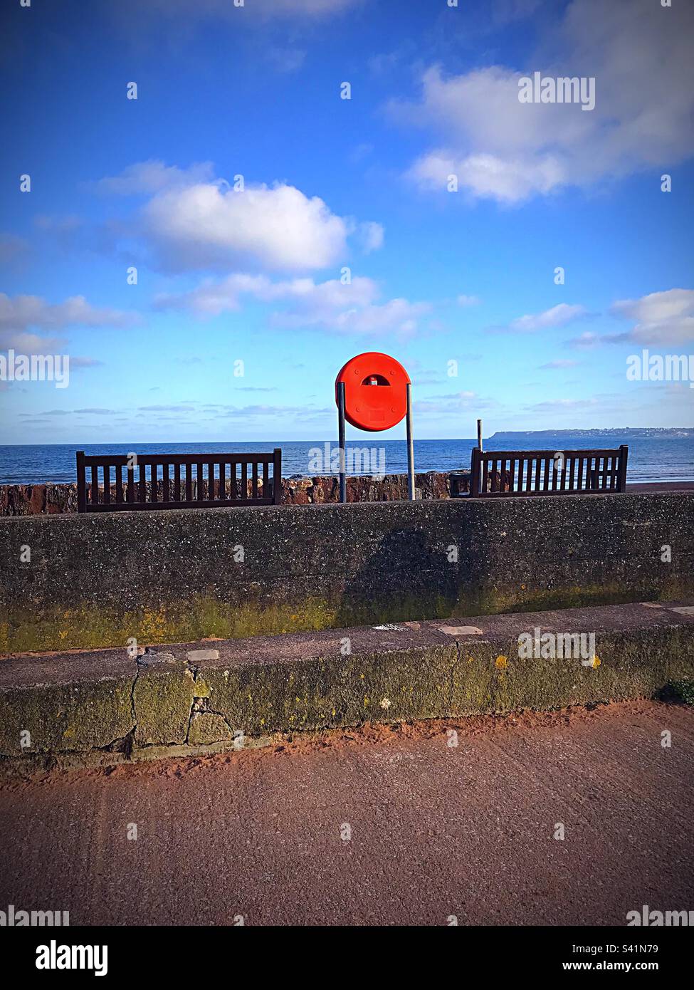 Two empty benches on seafront on a sunny winters day . In between a ...