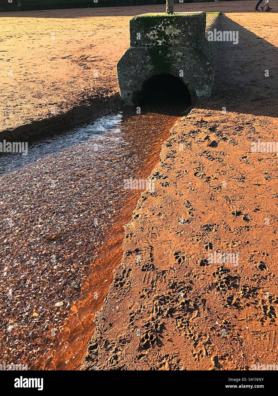 Pipe brings overflow clear water onto the beach and out to the sea from ...